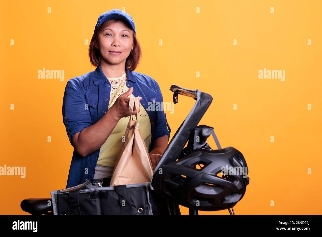 Takeaway food delivery worker wearing pizzeria uniform while delivering ...