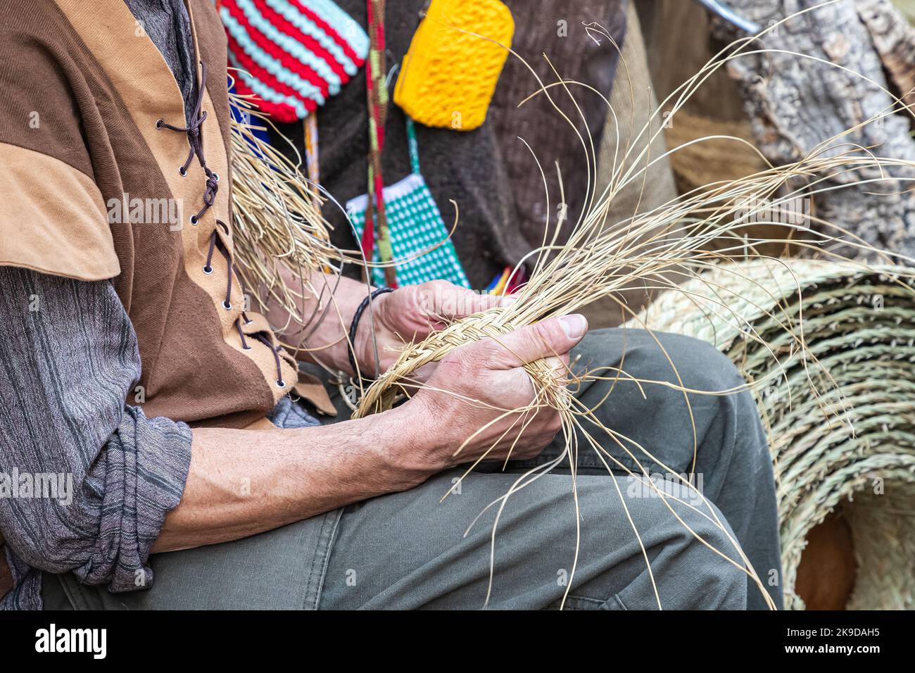 closeup in horizontal view of the hands of a basket maker showing how ...