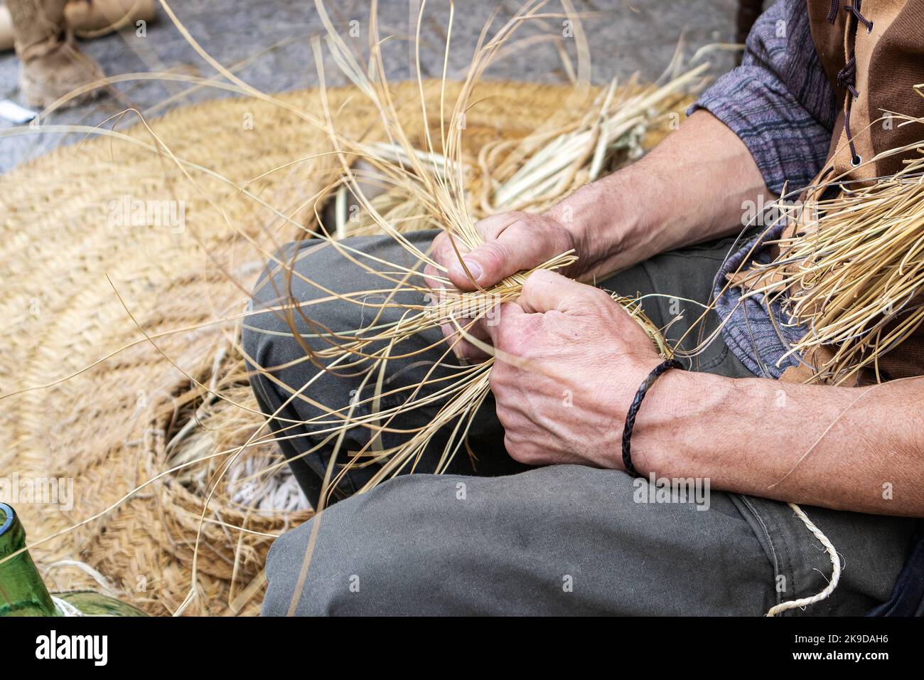 closeup in horizontal view of the hands of a basket maker showing how ...