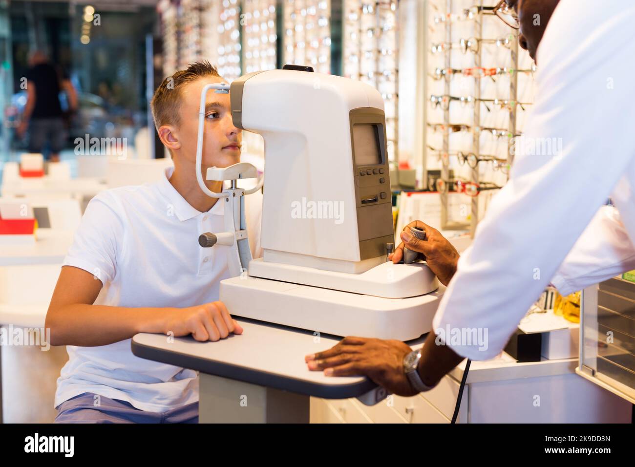 Optician testing teenager eyesight on refractometer Stock Photo - Alamy