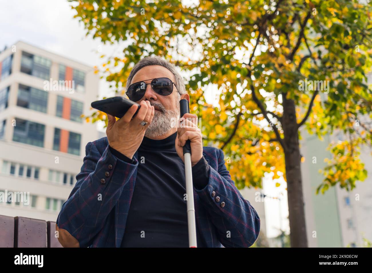 Middle-aged blind man with grey hair and beard wearing sunglasses and ...