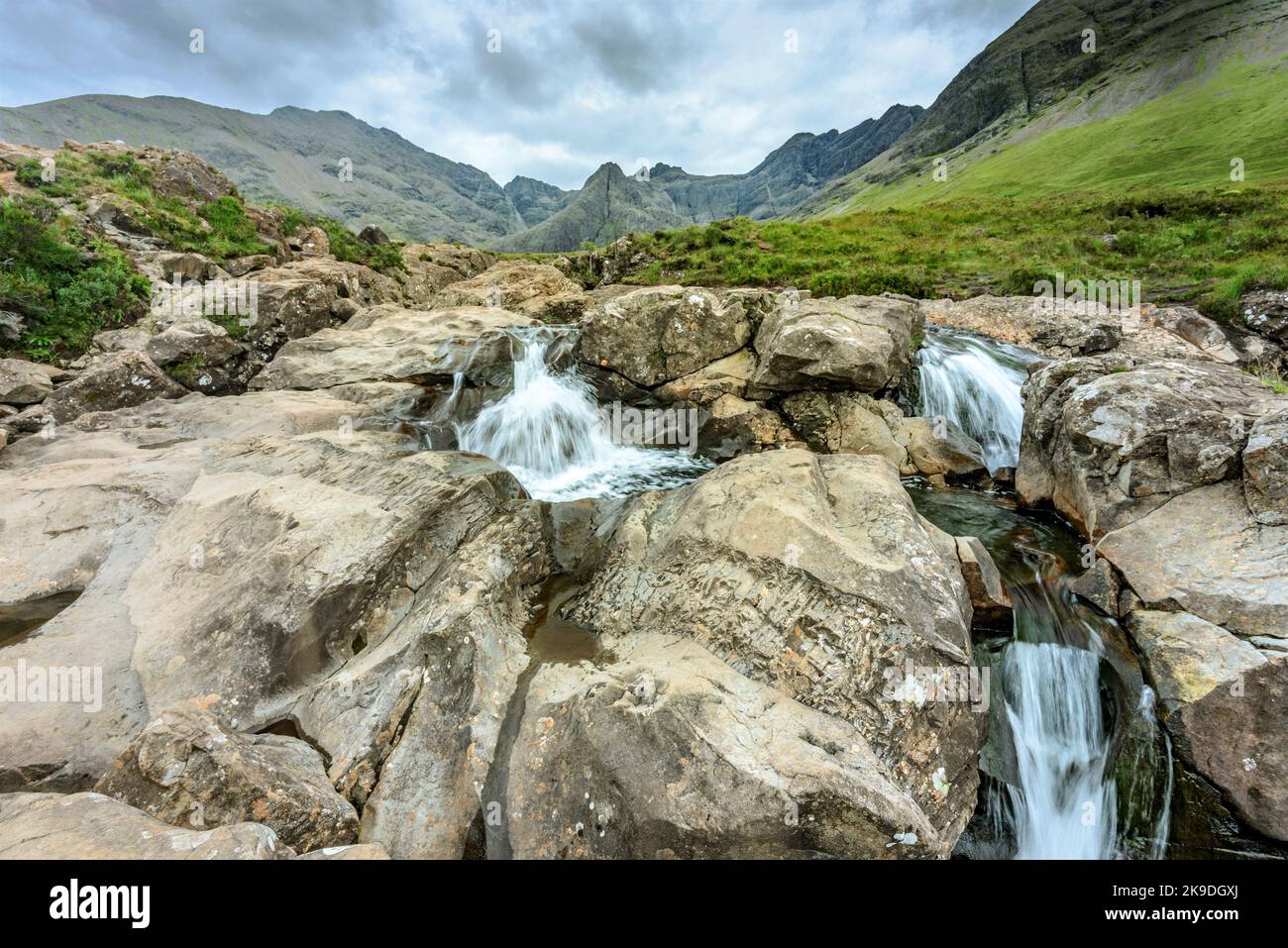 Long line of waterfalls and rocky mountain pools at the foot of the ...