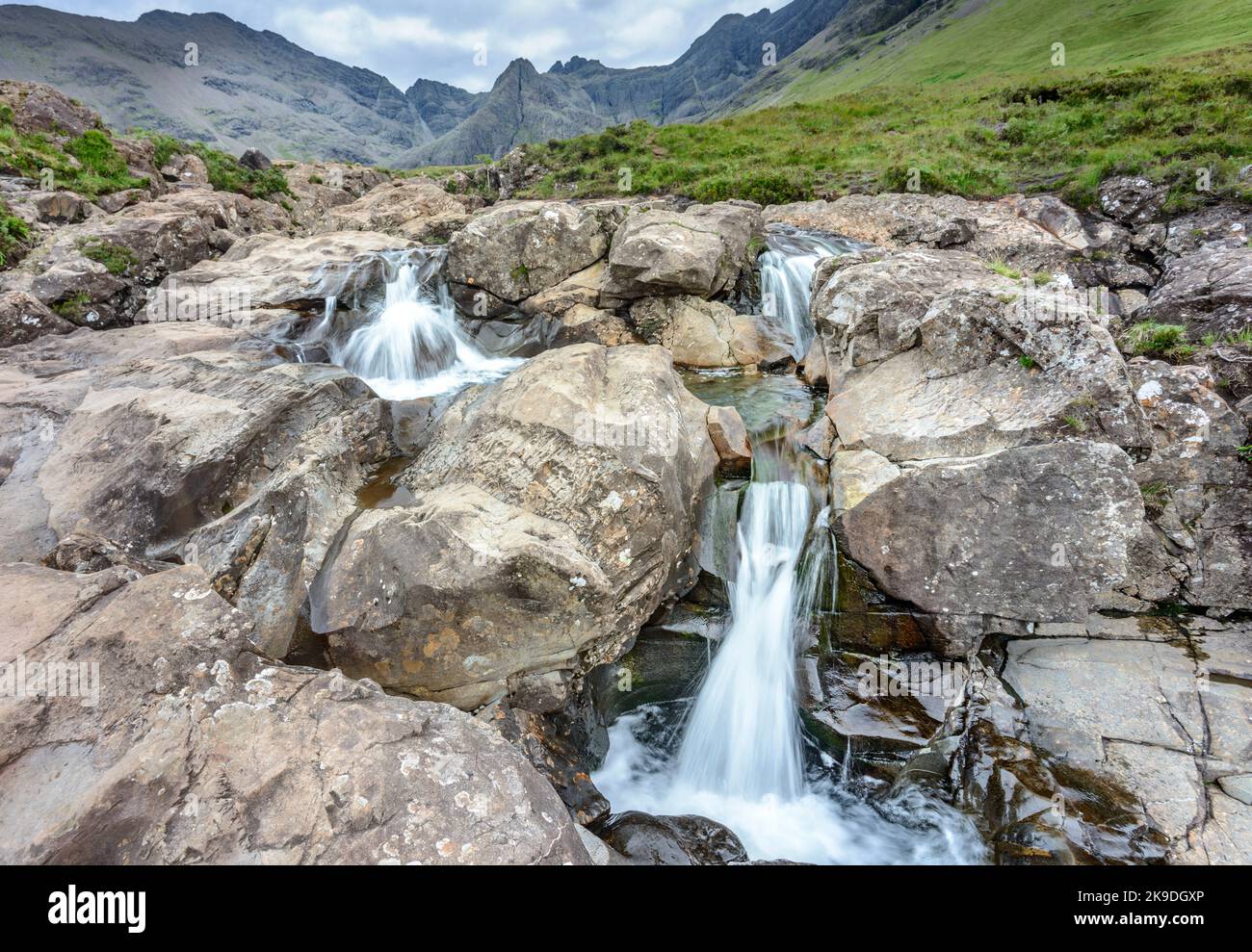 Long line of waterfalls and rocky mountain pools at the foot of the ...