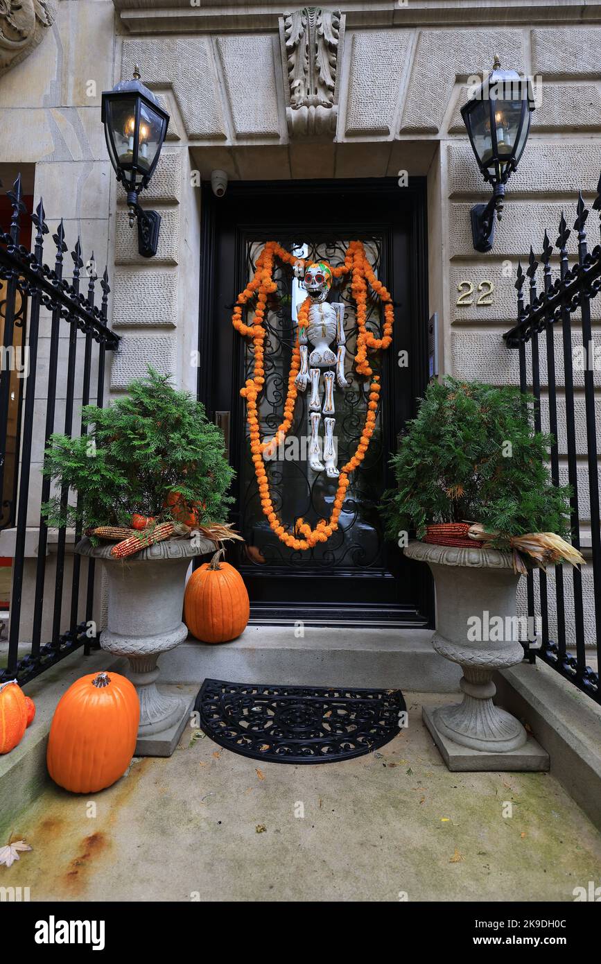 NEW YORK, NEW YORK - October 25, 2022: A skeleton with a pumpkin wreath ...