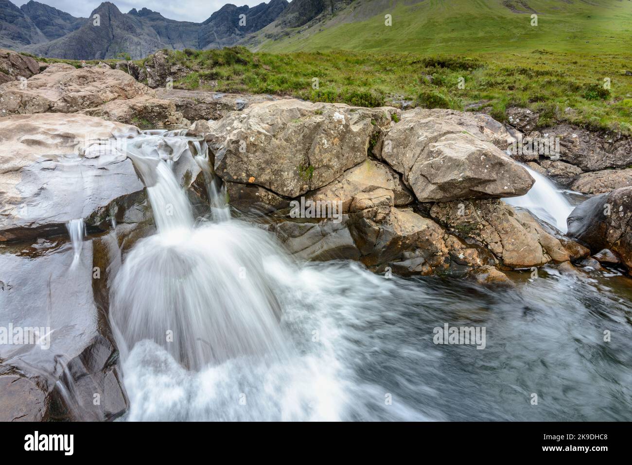 Long line of waterfalls and rocky mountain pools at the foot of the ...