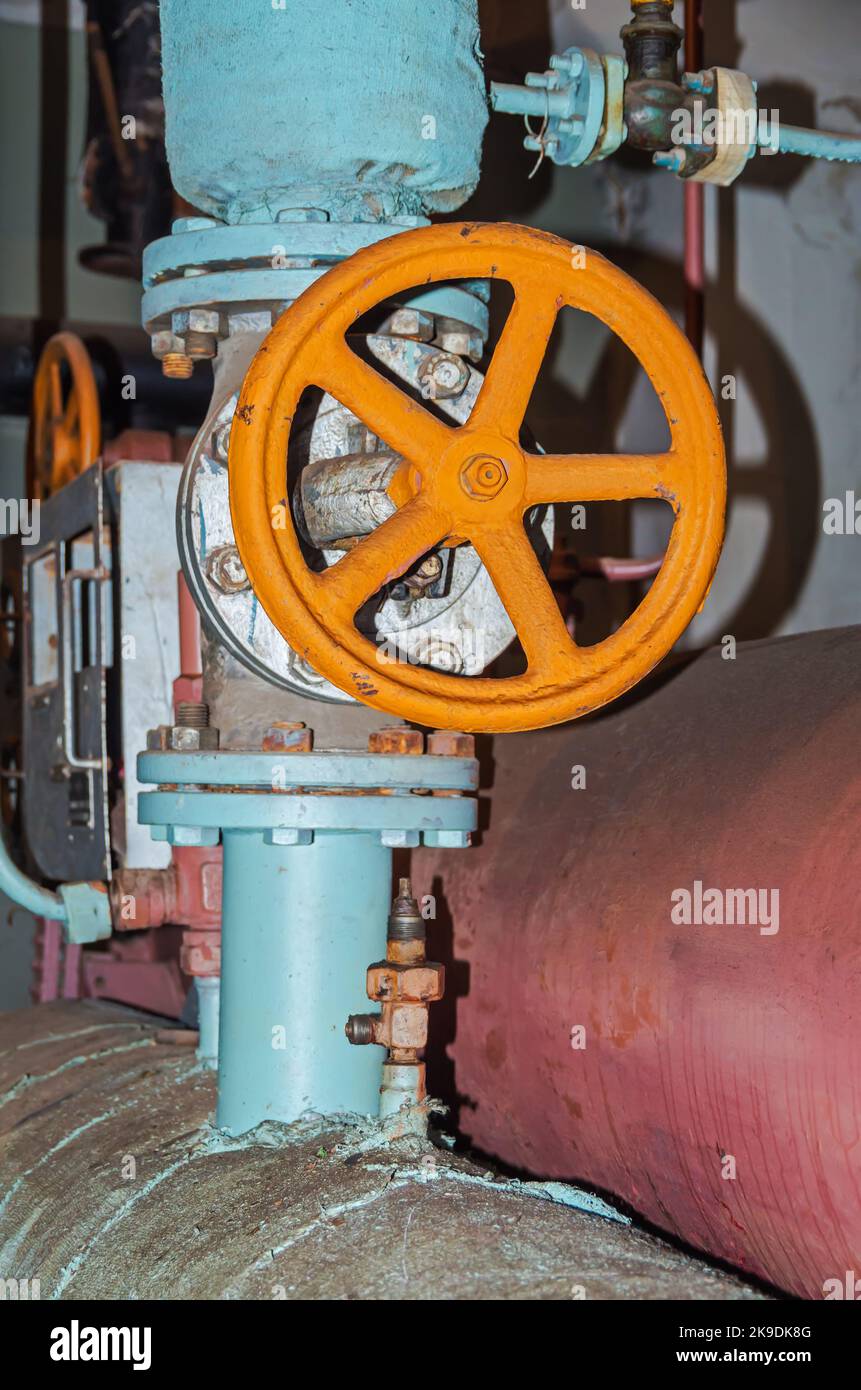 Obsolete plumbing orange color valve and big pipe with in abandoned ...