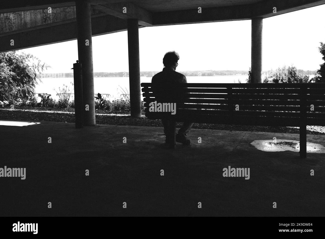 Man sitting alone on a bench Stock Photo - Alamy