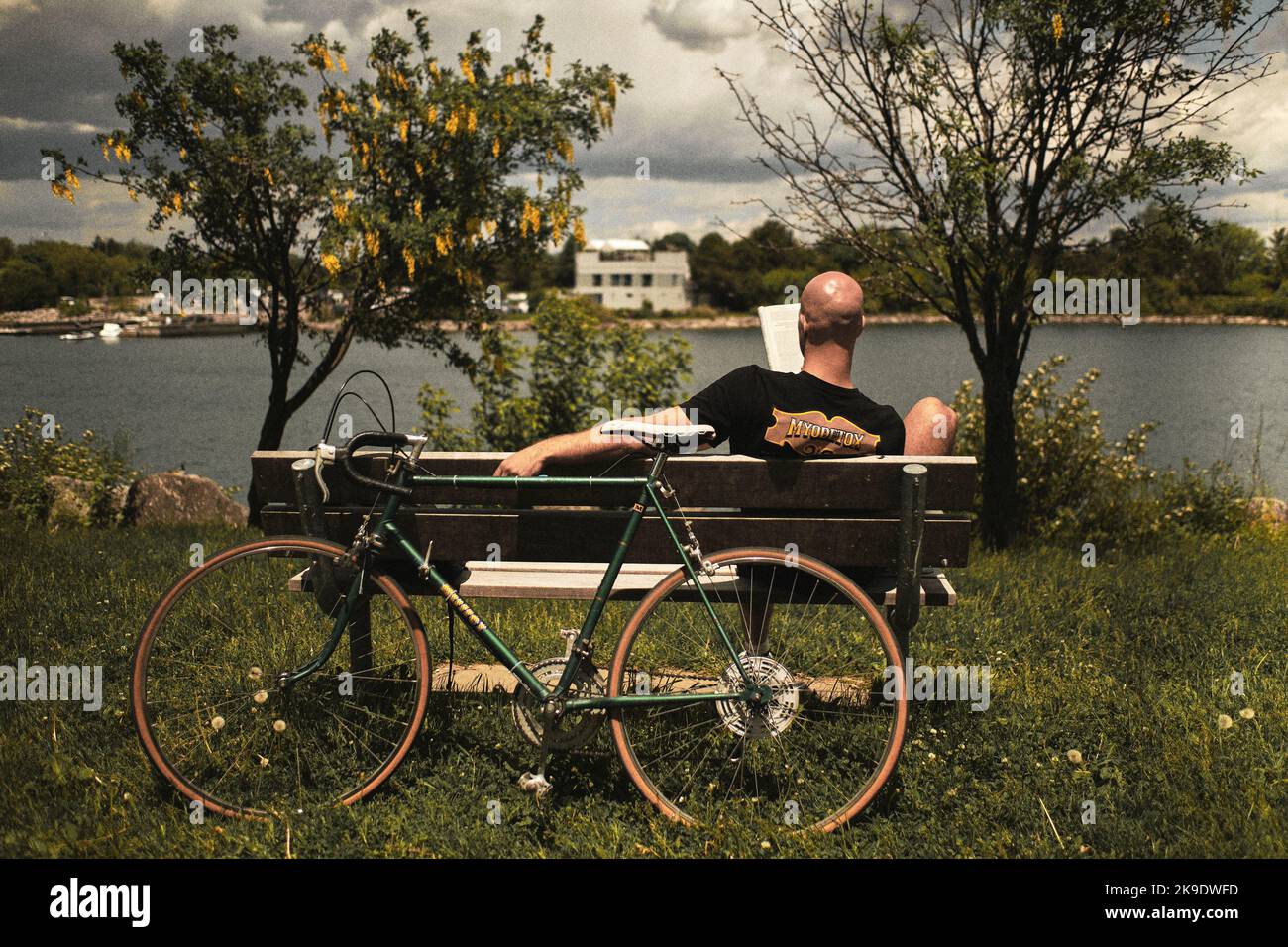 Reading On A Bench With A Bike Stock Photo - Alamy