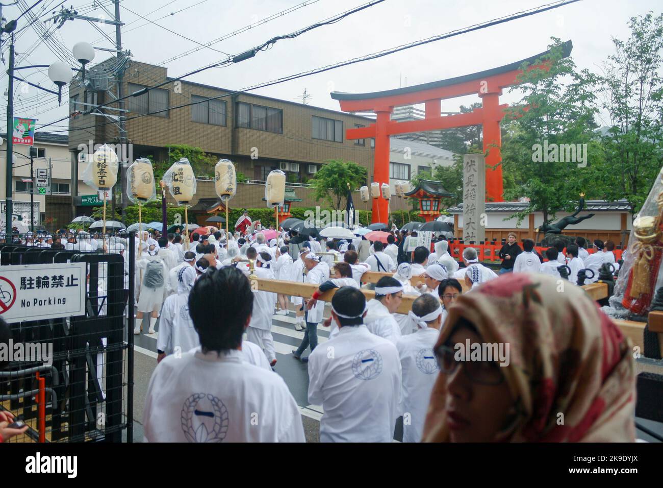 Crowd of people wearing white costume gather in street at front of ...