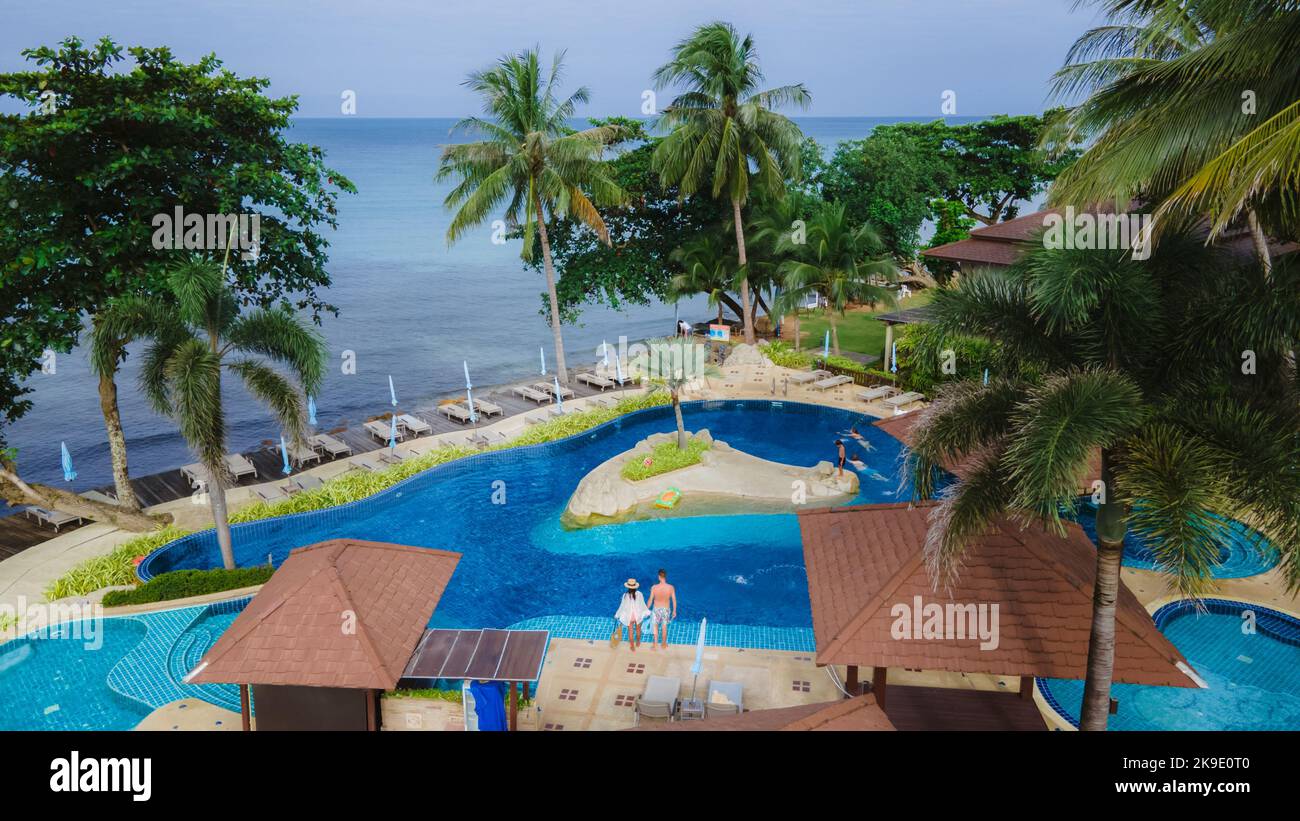 Drone aerial view of a luxury hotel pool from above. A couple of men ...