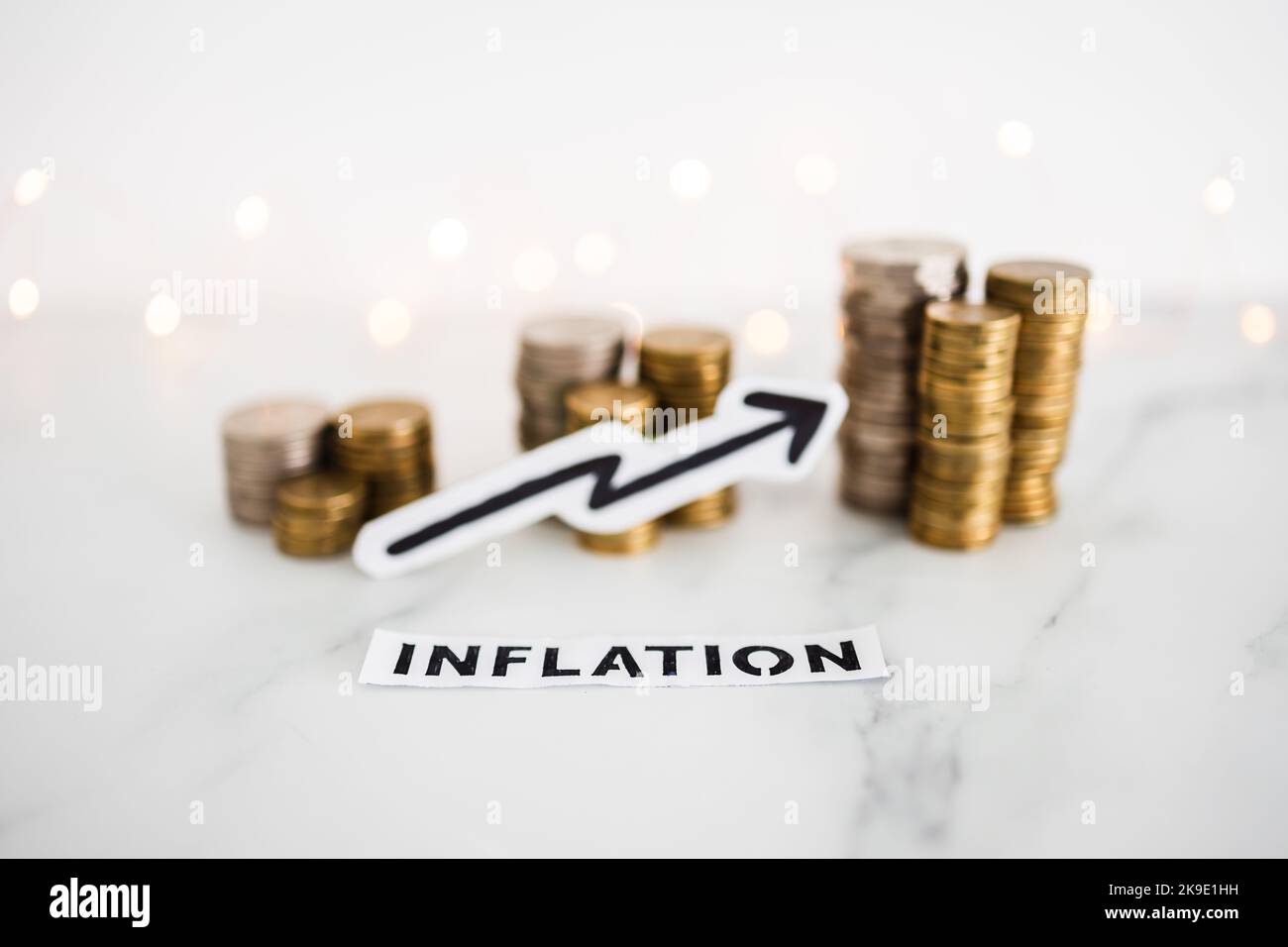 inflation with arrow going up in front of growing stacks of coins ...