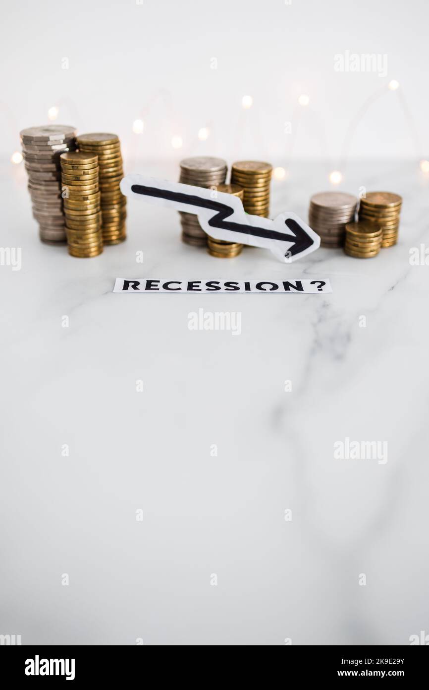 recession text with arrow going down in front of decreasing stacks of ...