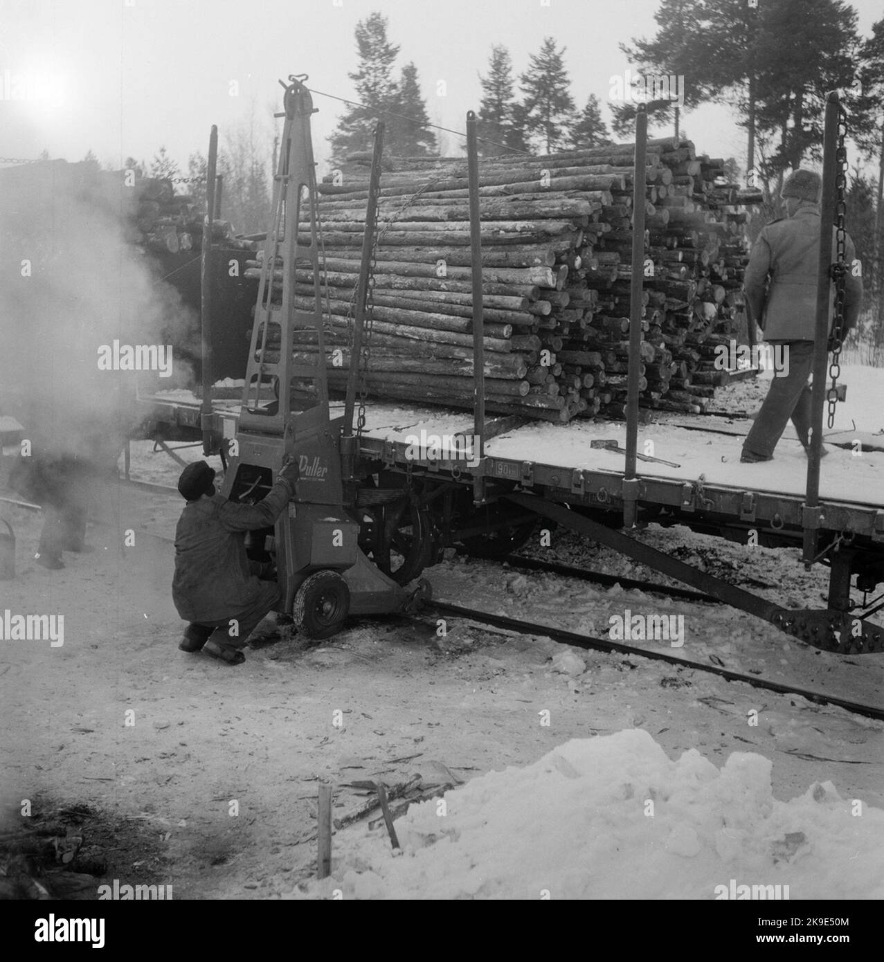 Loading of timber from truck to freight wagon with puller timber ...