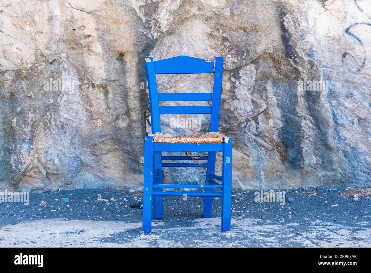 Old blue wooden chair near the rock Stock Photo - Alamy
