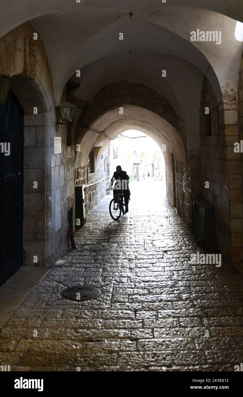 A man riding his bicycle on the old cobbled street of the Christian ...