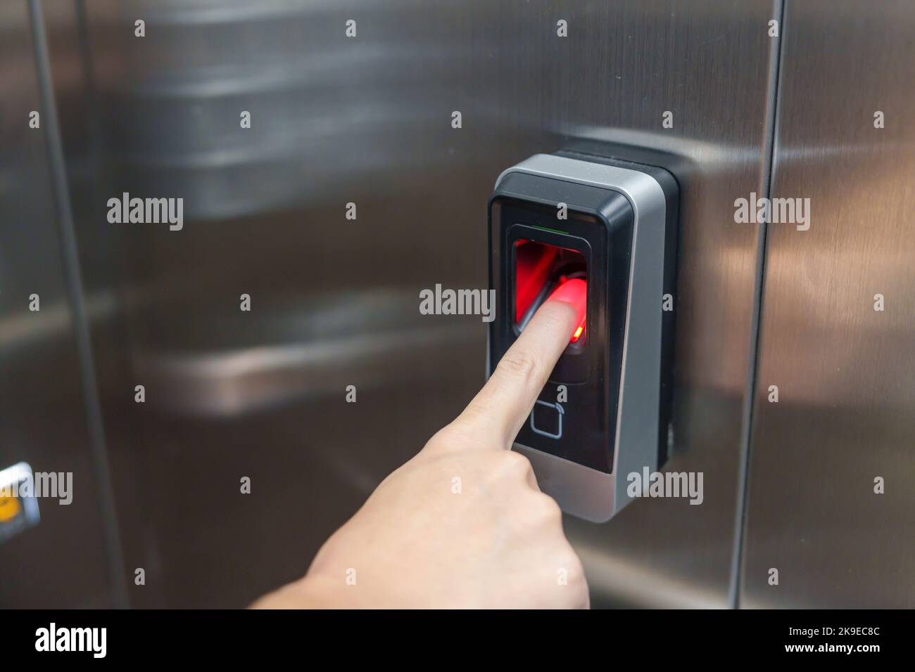 Woman using finger to fingerprint scanner in Elevator. Security system ...
