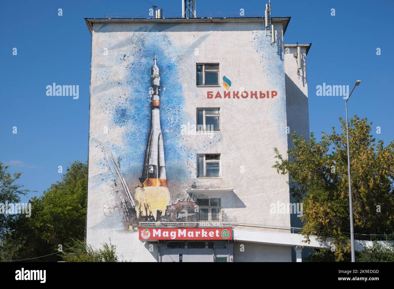 A large painted mural on the side of an apartment building, depicting a ...
