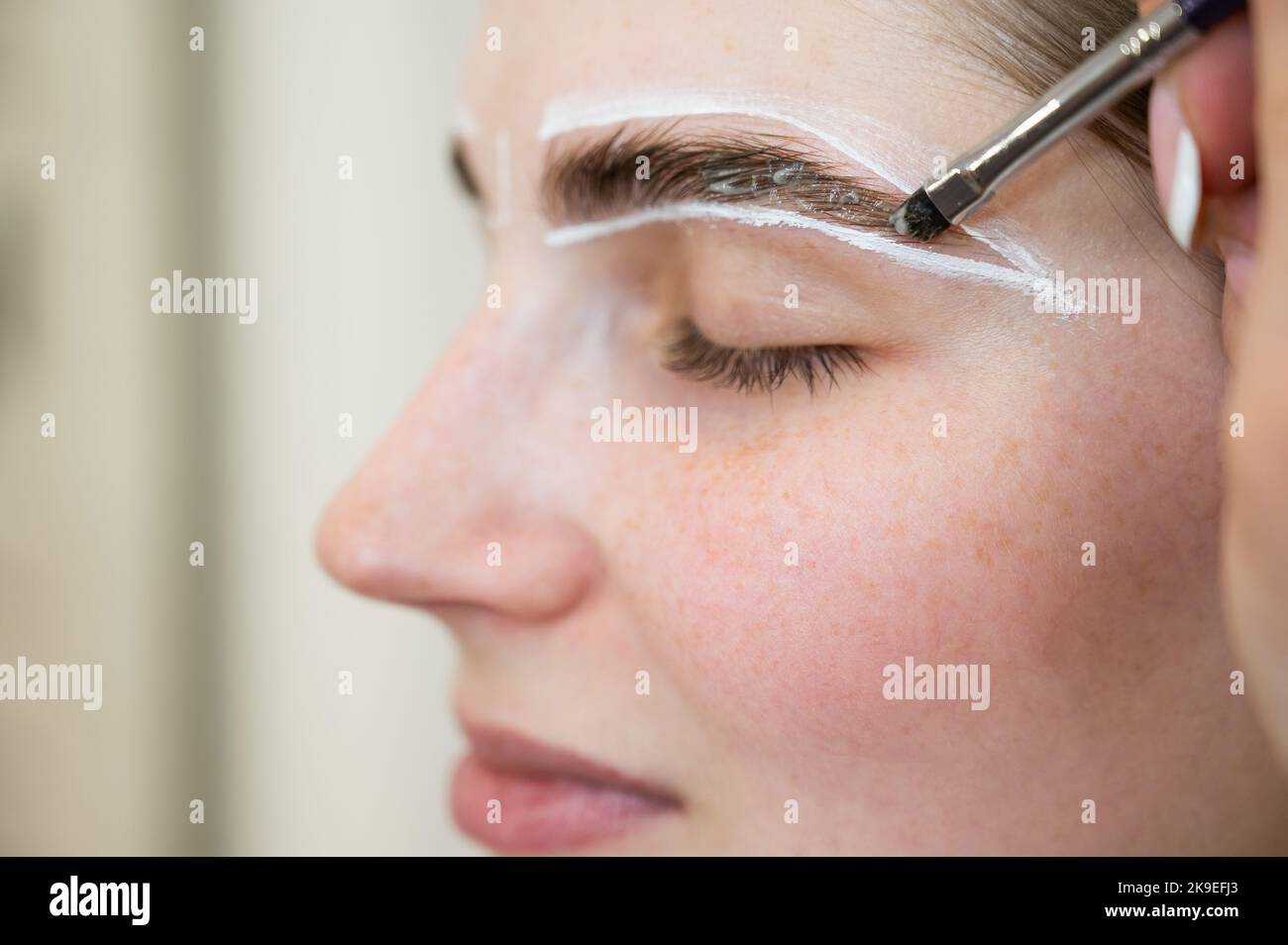 The master draws the shape of the eyebrows with white paint before ...