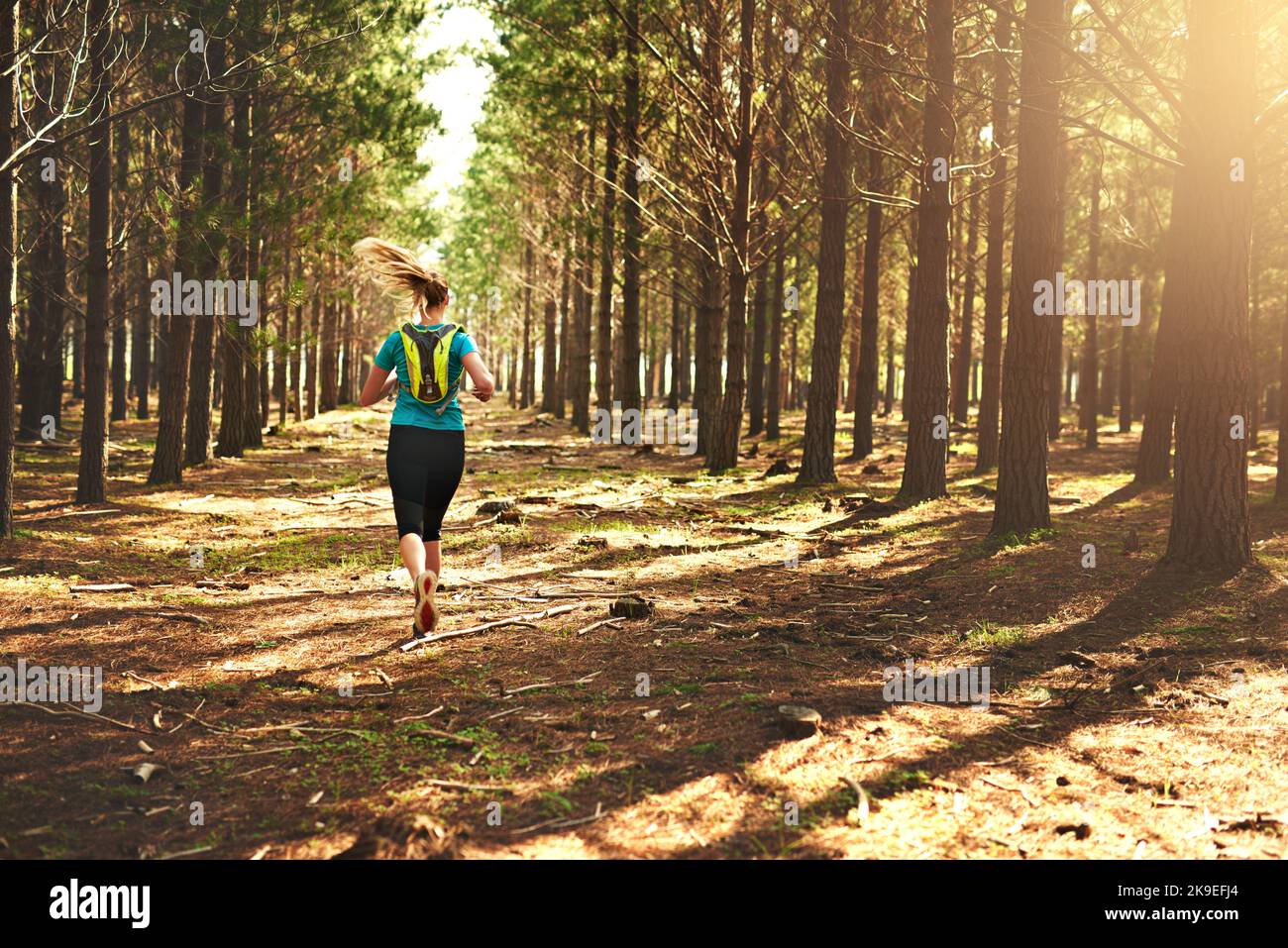 Its a beautiful thing being in nature. a young woman out running in the ...