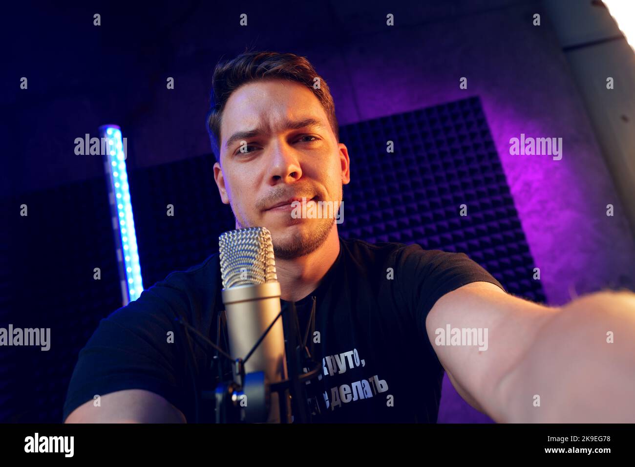 Young man in recording studio using microphone Stock Photo - Alamy