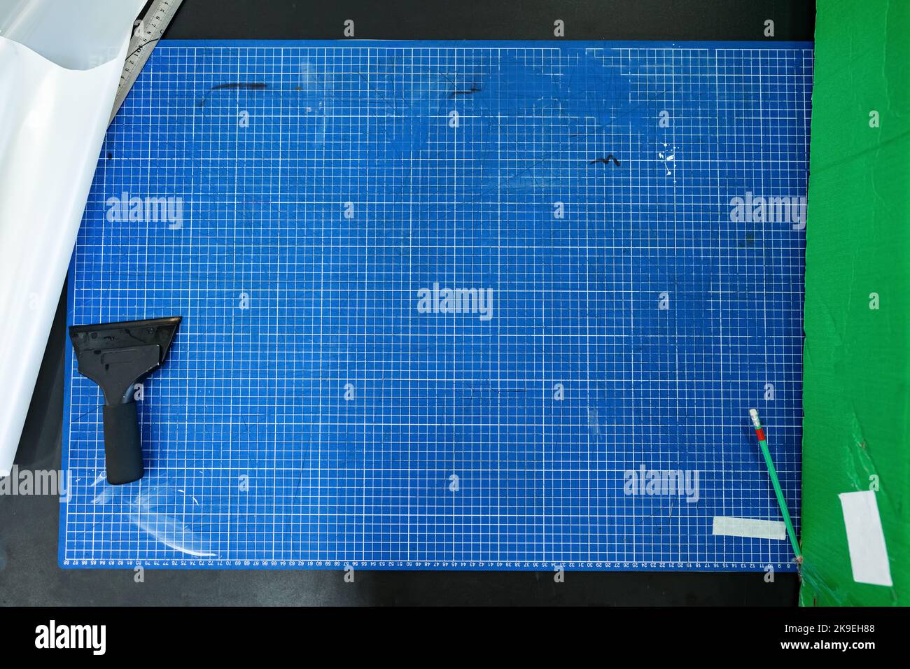 Desktop top view with blue cutting mat Stock Photo - Alamy