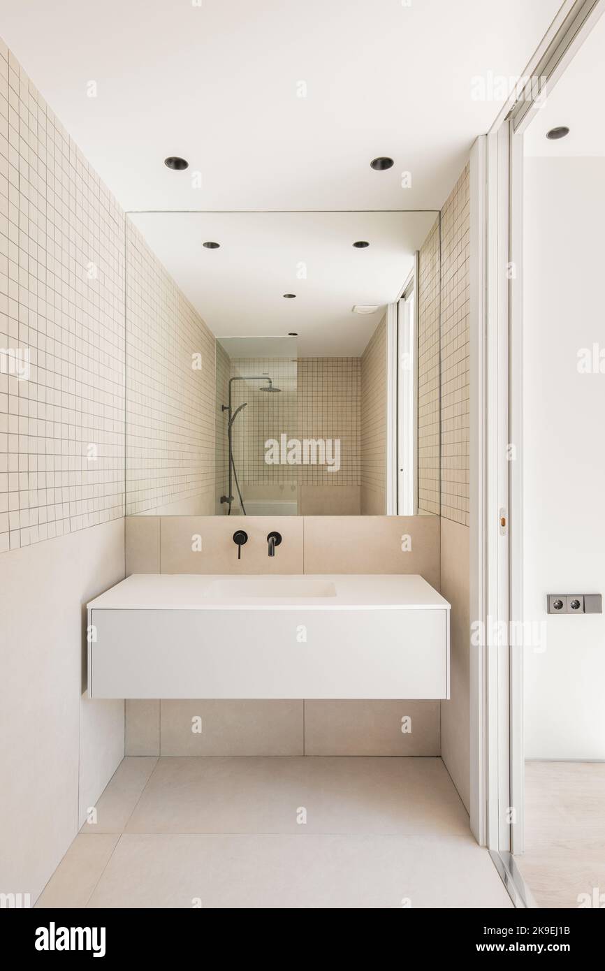 Modern bathroom with beige tiles. shower zone with glass partition ...