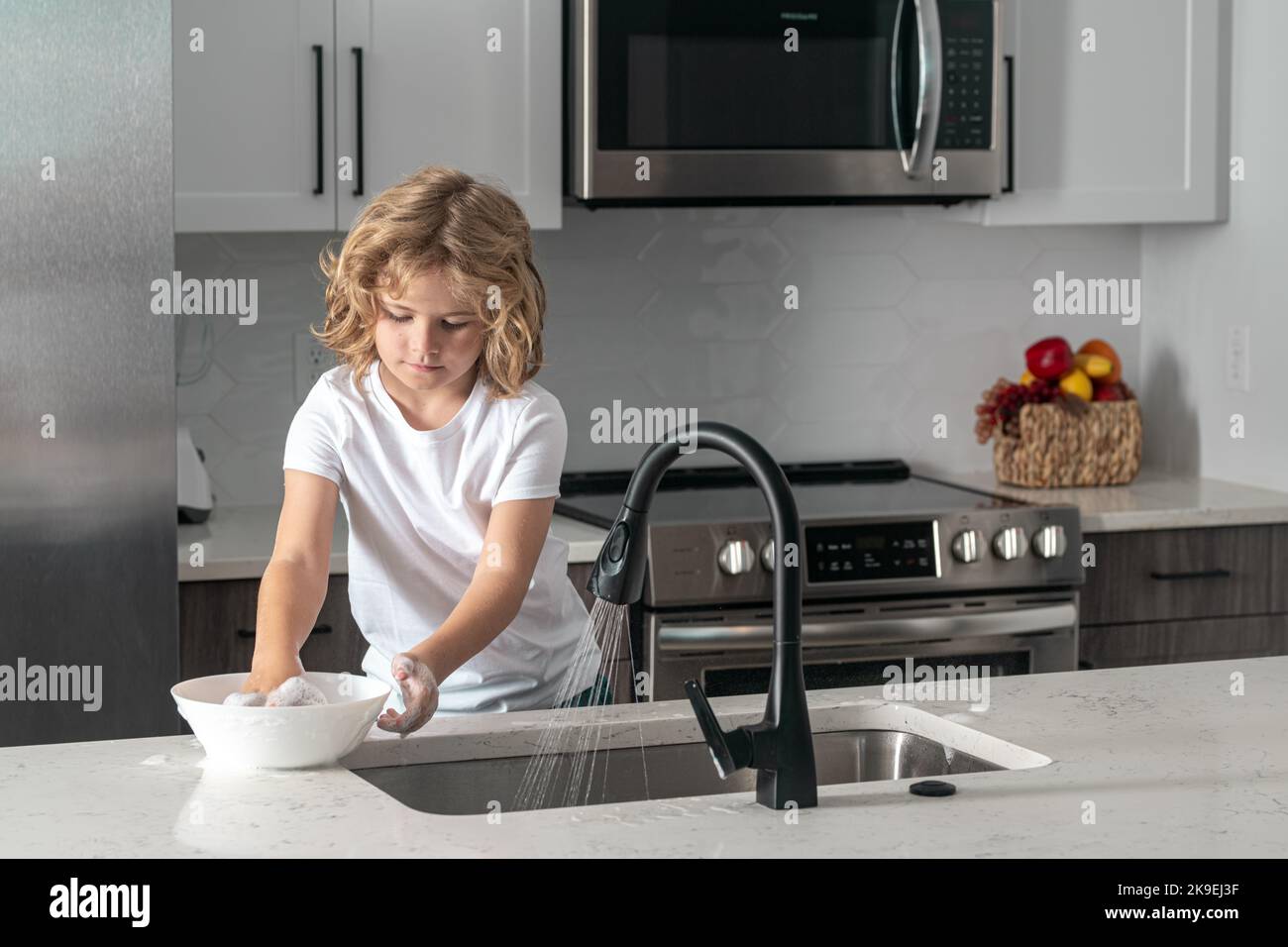 Child cleaning dishes with sponge. Cleaning supplies. Help clean-up ...