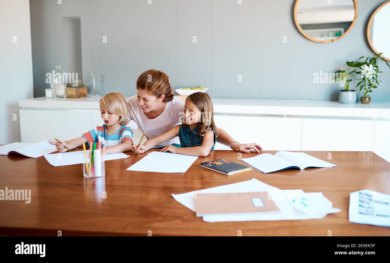Every mom is their childs first teacher. a young mother helping her two ...
