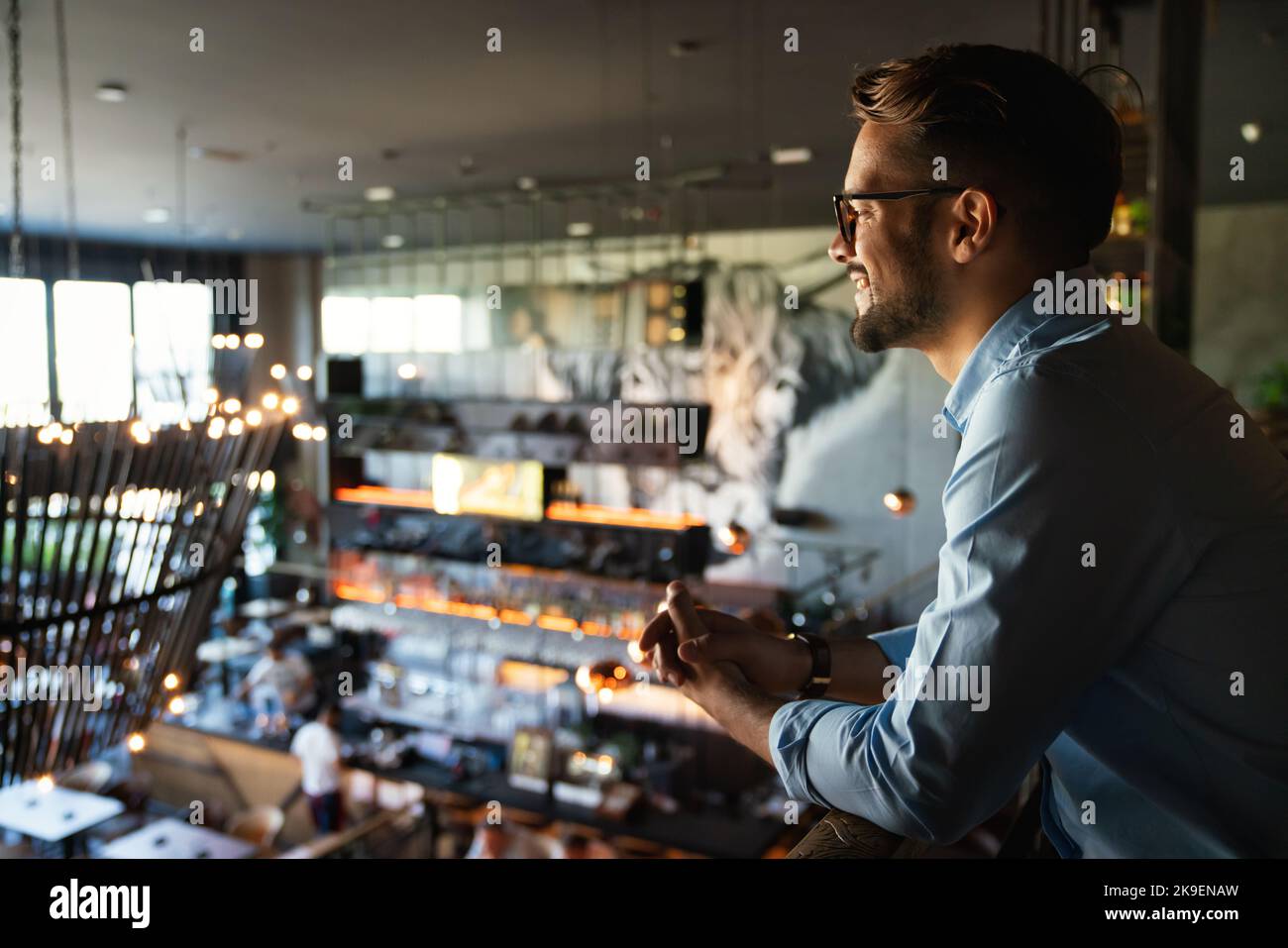 Happy businessman, restaurant owner proudly looking at crowded ...
