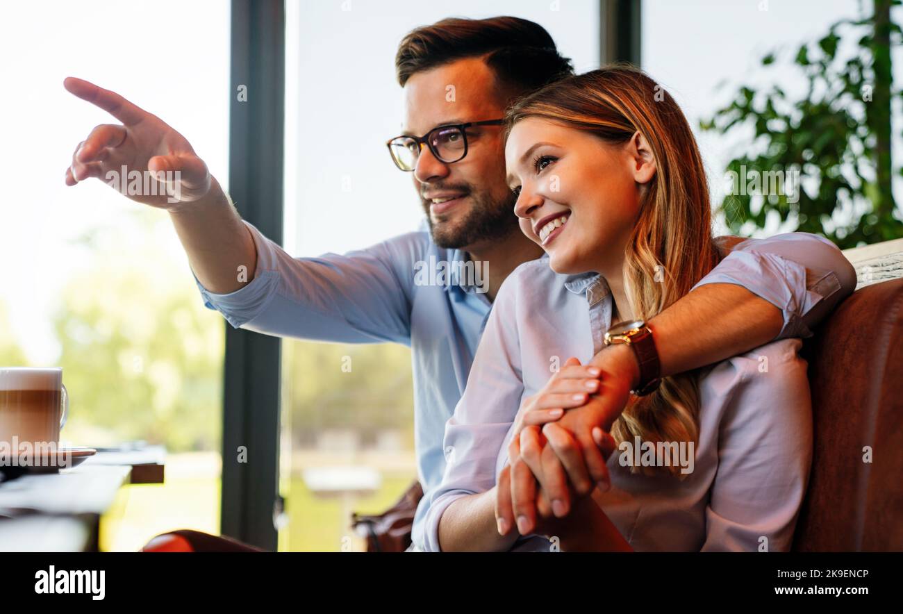 Happy Couple Hugging Sitting On A Couch And Looking Outdoors Through