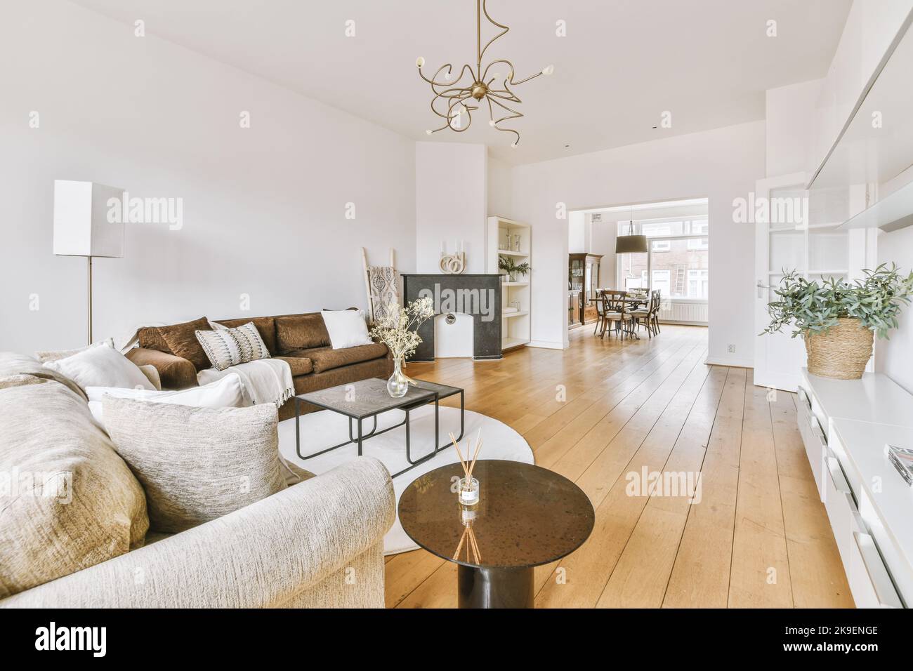 Comfortable sofa with soft cushions located under stylish chandelier in ...