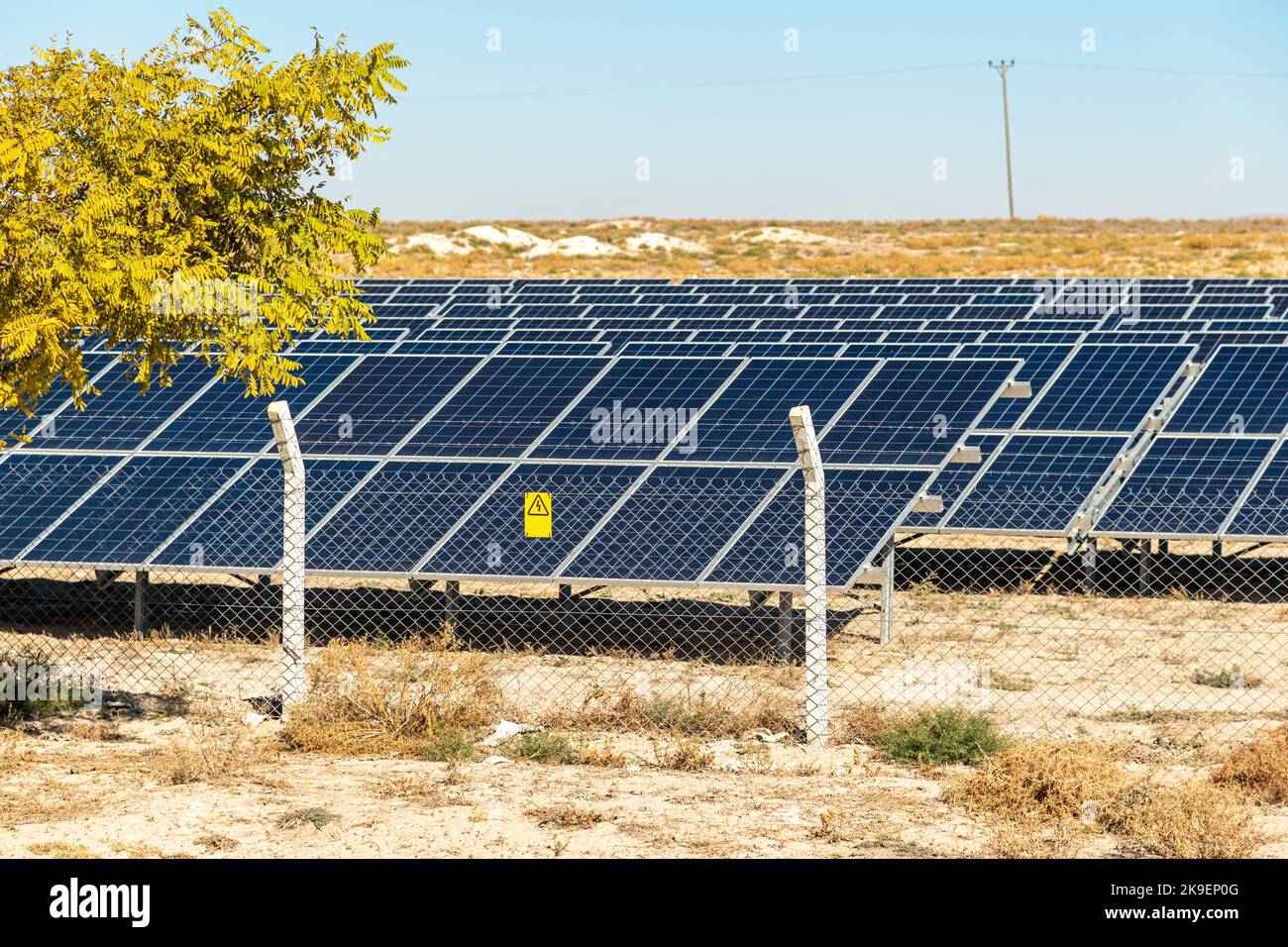 Solar field with fenced solar panels at sunset Stock Photo - Alamy