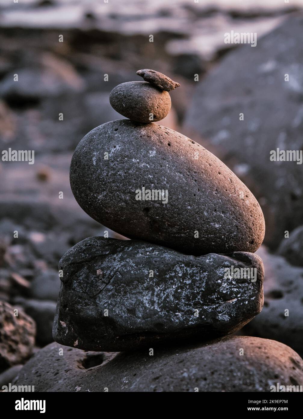 Stones balanced on top of each other to build a cairn at the beach ...