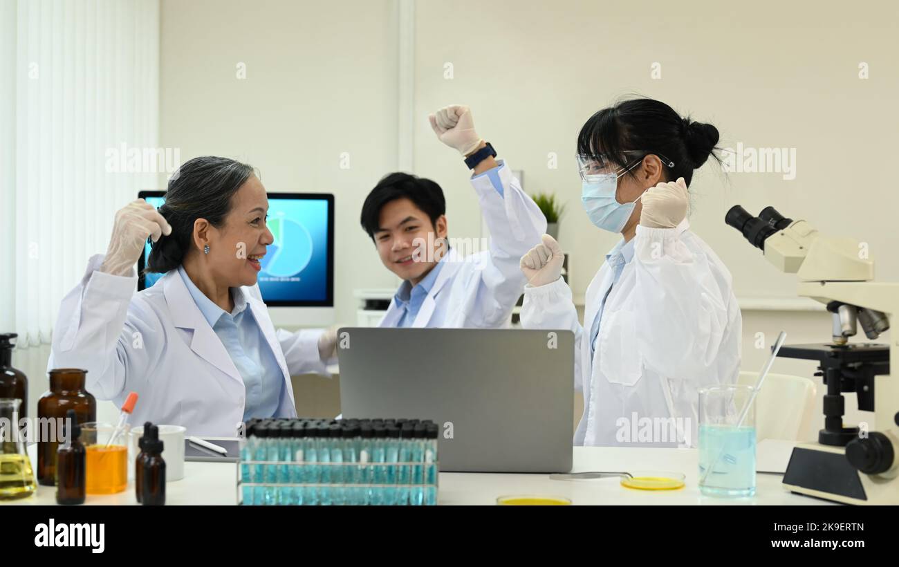 Professional scientist team celebrating success results of the ...