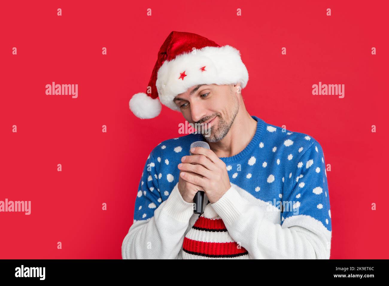 christmas song. shy man singing christmas song with microphone in ...