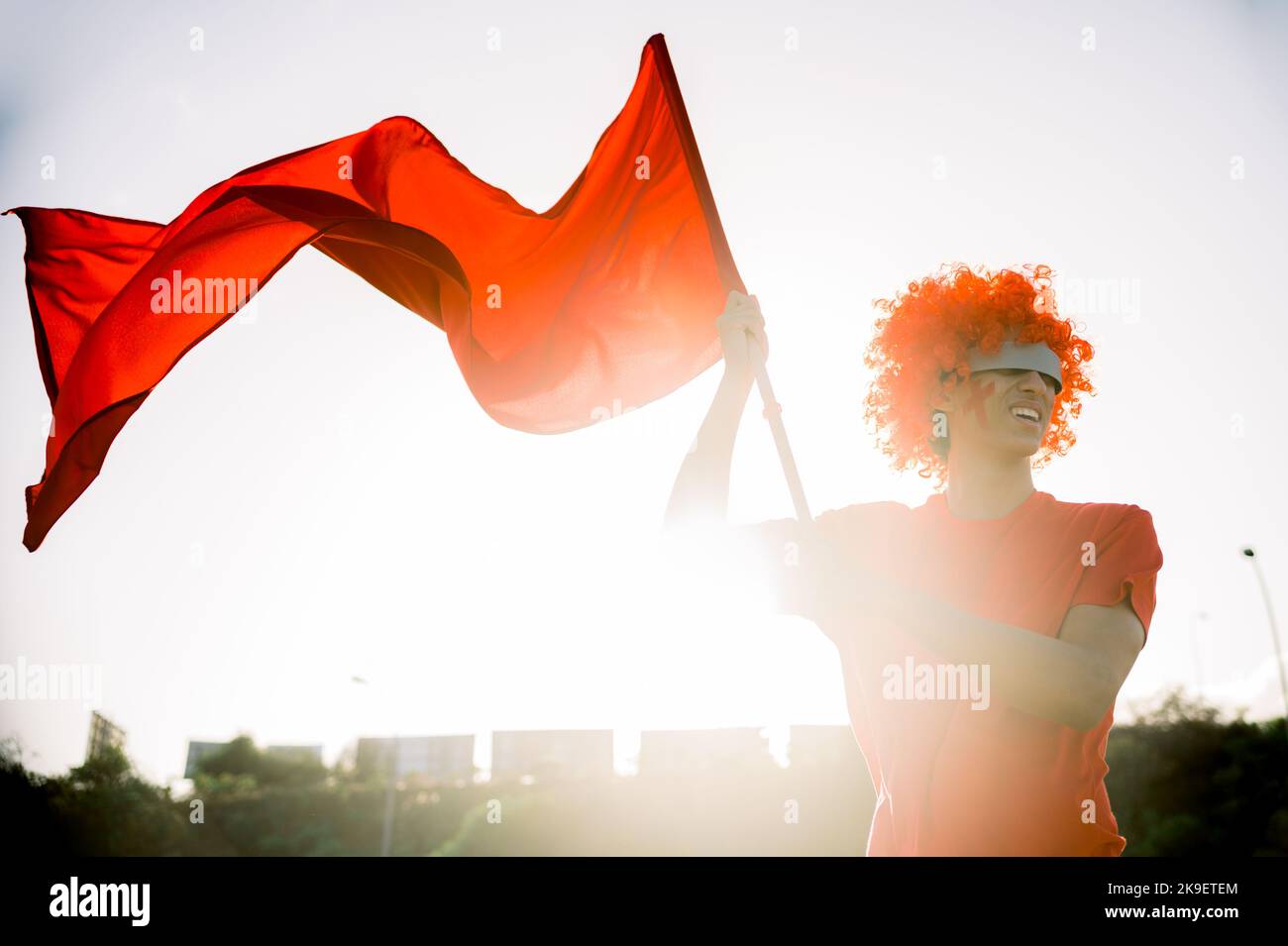 Young ethnic man in VR glasses waving flag on street Stock Photo - Alamy