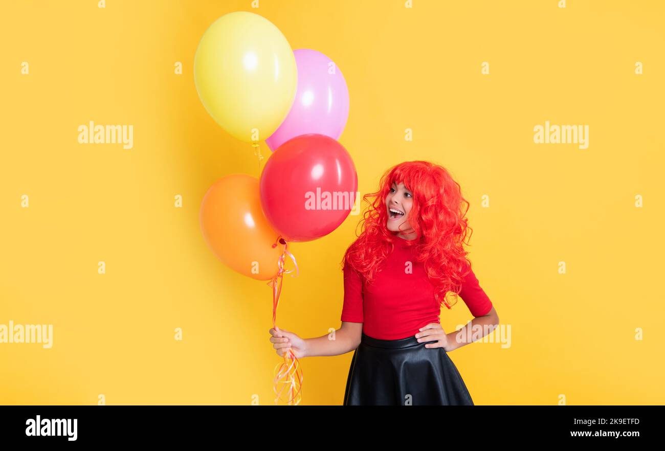 surprised child with party balloon on yellow background Stock Photo - Alamy