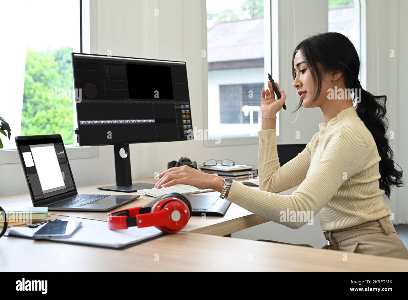 Young female content creator editing video footage with professional ...