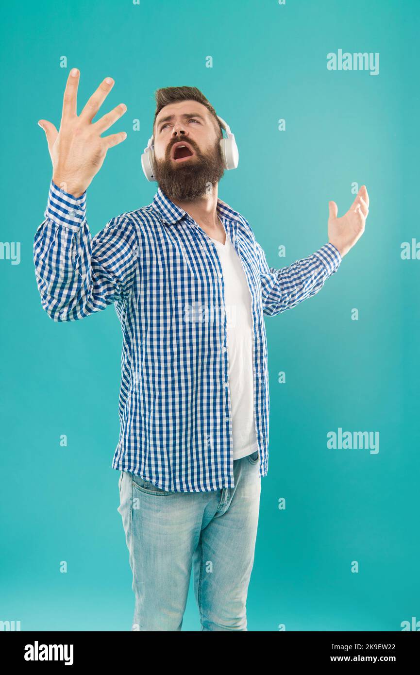 singing bearded man in casual checkered shirt listen song in heaphones ...