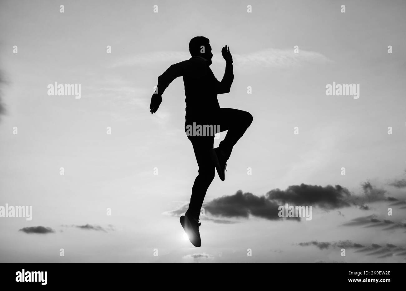 energetic man runner silhouette running to future against sunset sky ...