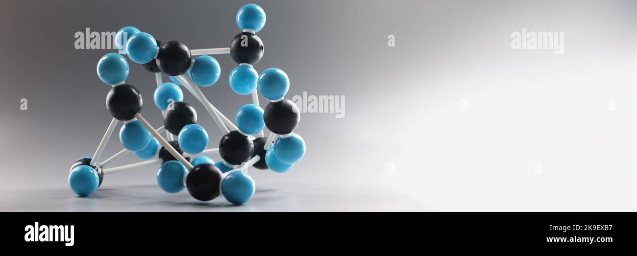 Molecular model structure, miniature on grey background, blue and black ...