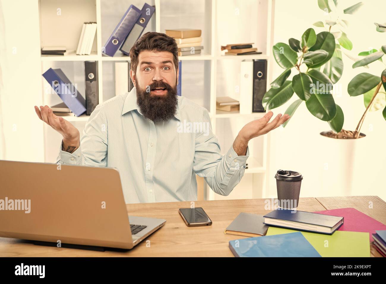Perplexed guy making helpless gesture working at office desk, perplexity Stock Photo - Alamy