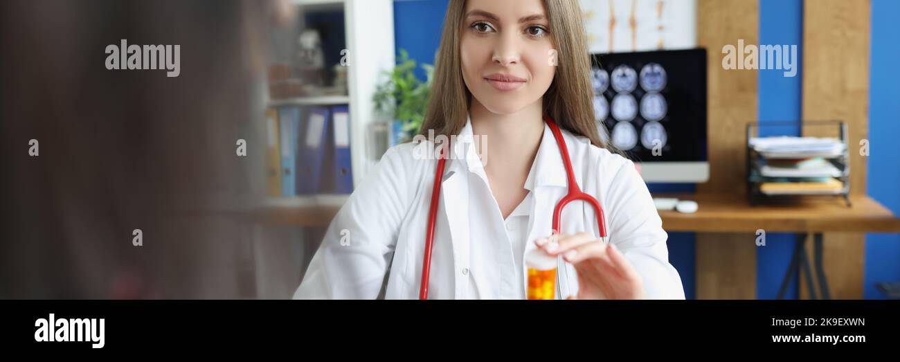 Female doctor give to patient plastic container filled with medication ...
