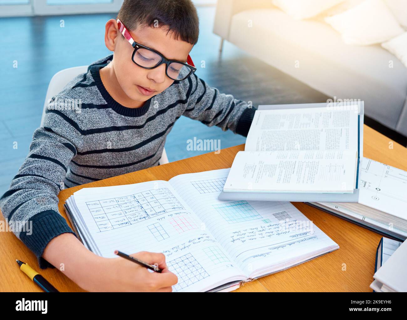 Hes becoming a wiz kid. a determined young boy doing his homework at ...