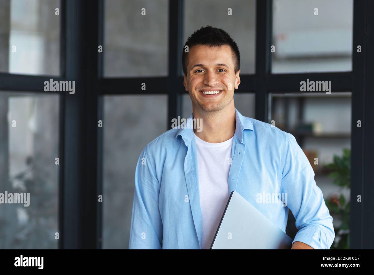 Portrait of successful young businessman or entrepreneur standing in ...