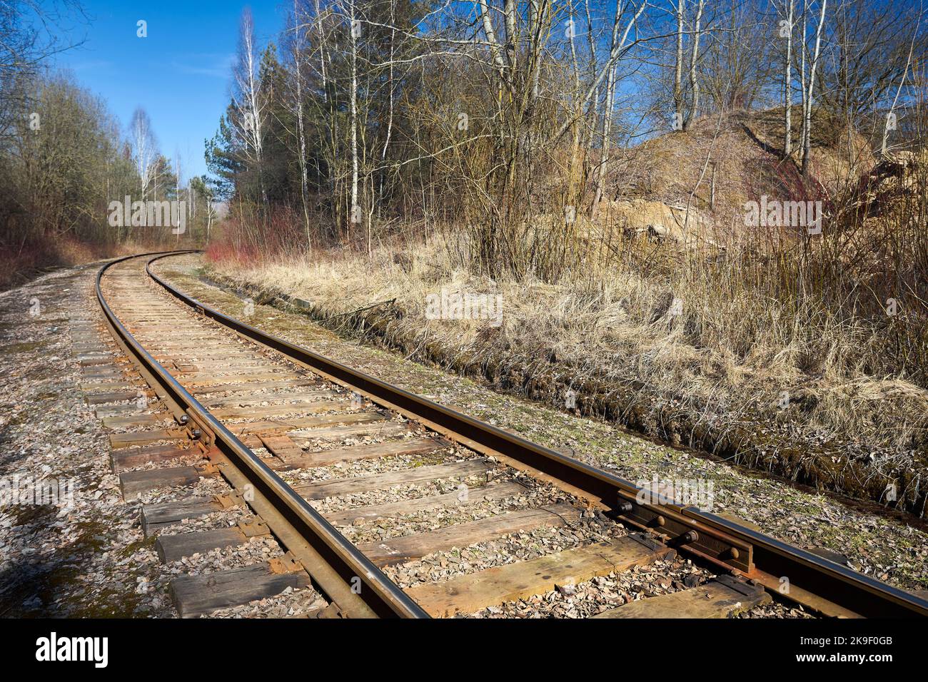 Railway track in the spring forest with blue sky with railway drainage ...