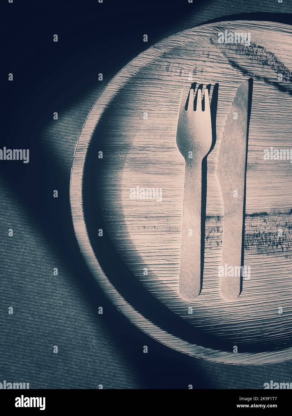 Empty wooden plate with fork and knife inside Stock Photo - Alamy