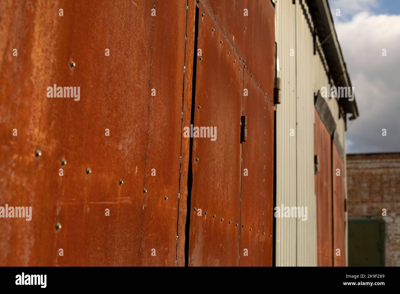 Rusty gates in industrial area. Warehouse details. Steel gates. Rust on ...