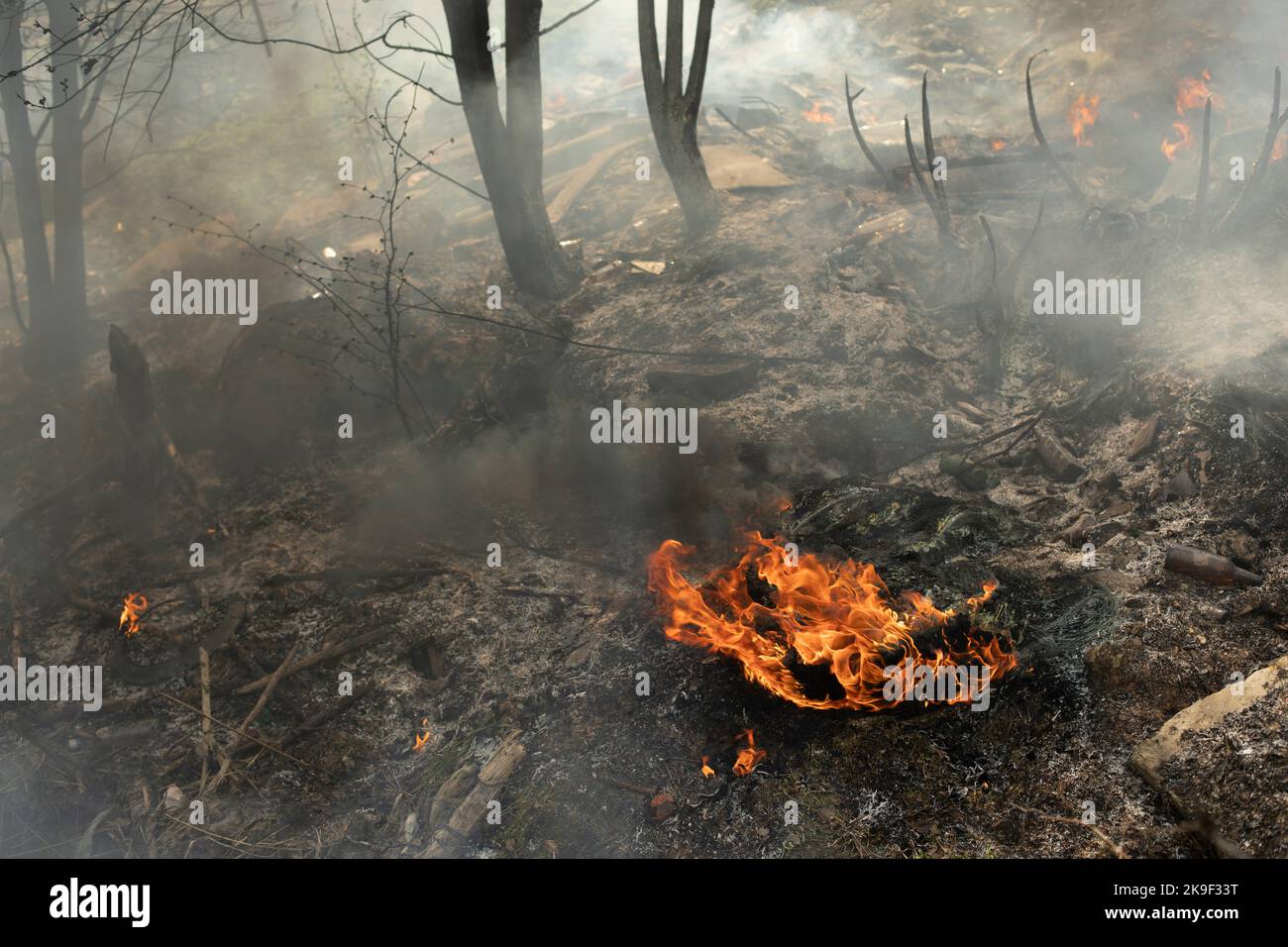 Black smoke from fire. Burning of garbage. Destruction of nature ...