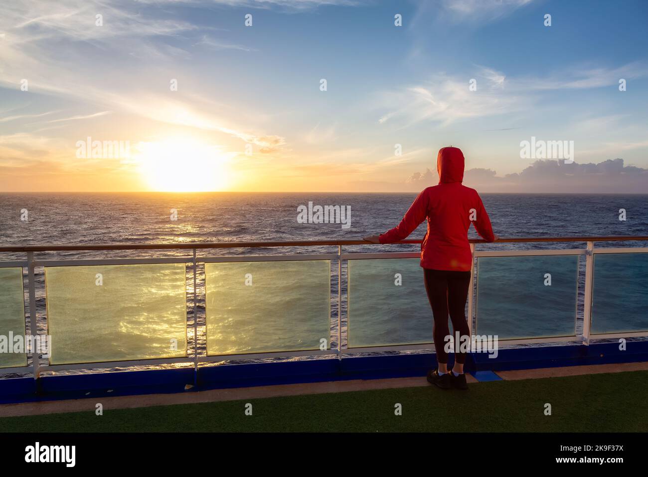 Adventure woman traveler enjoying colorful sunset from a Cruise Ship ...